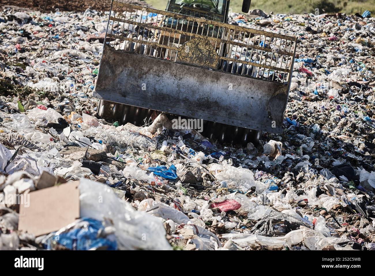 Heavy machinery shredding garbage in an open air landfill. Waste Stock ...