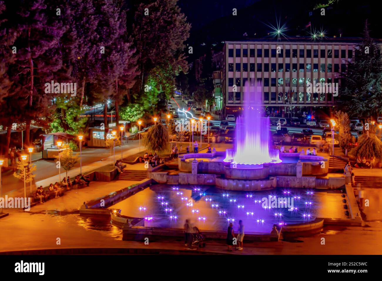 City square with fountains. Night square with colorful flowers. Night ...