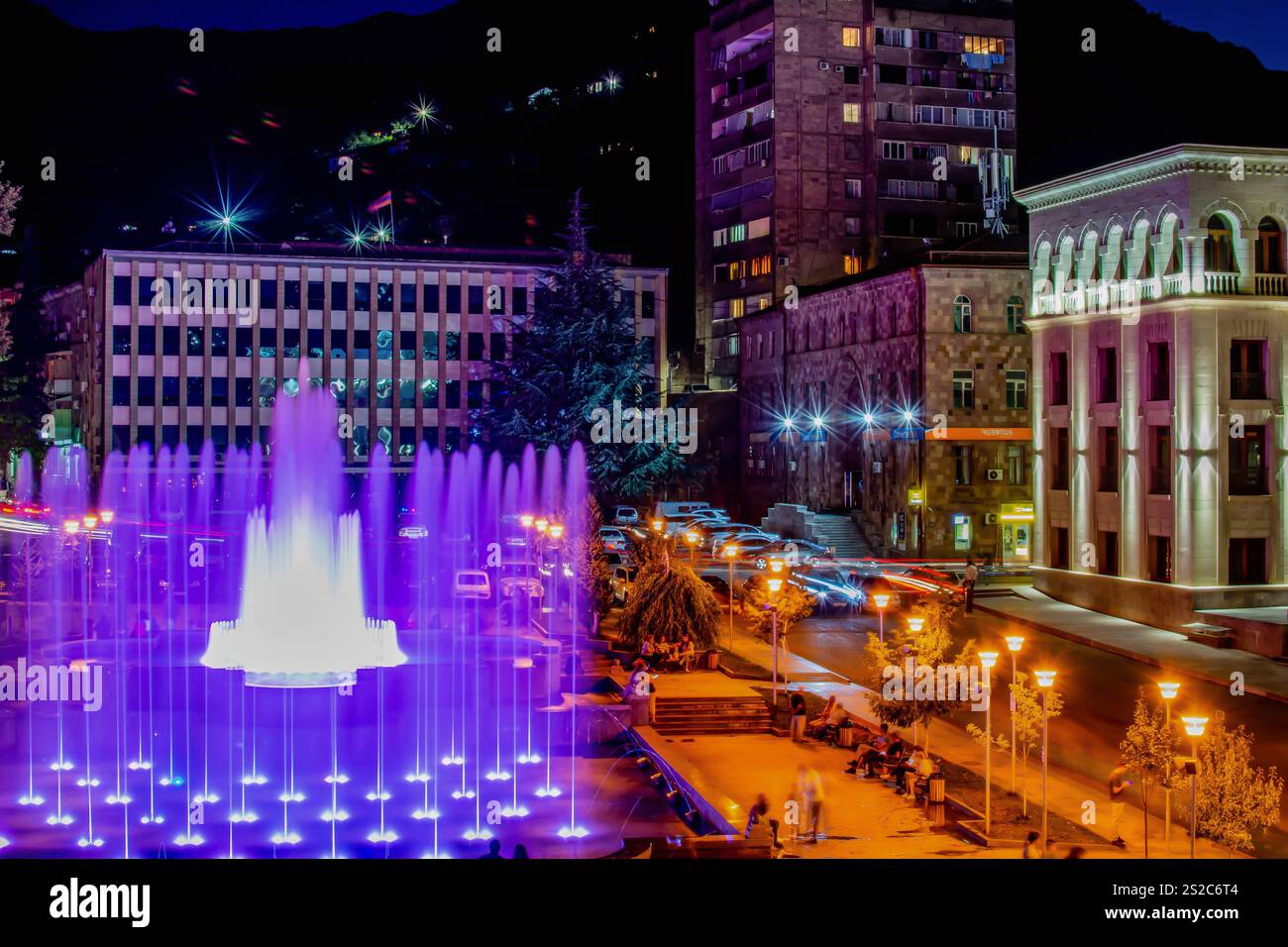 City square with fountains. Night square with colorful flowers. Night ...