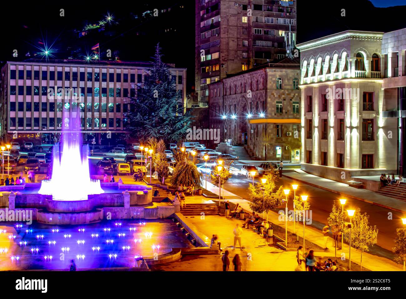 City square with fountains. Night square with colorful flowers. Night ...