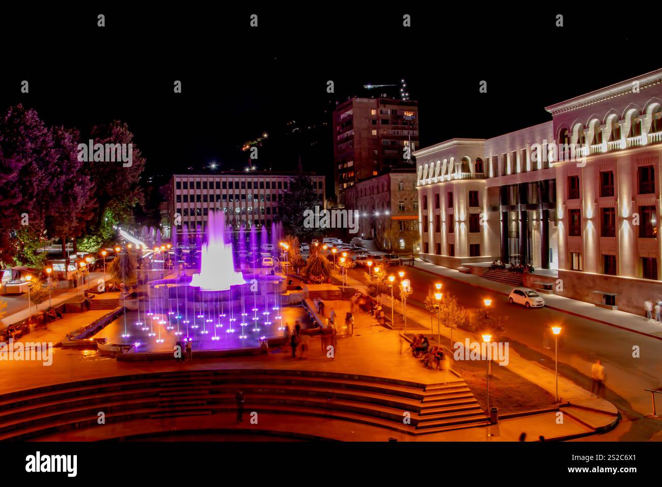 City square with fountains. Night square with colorful flowers. Night ...