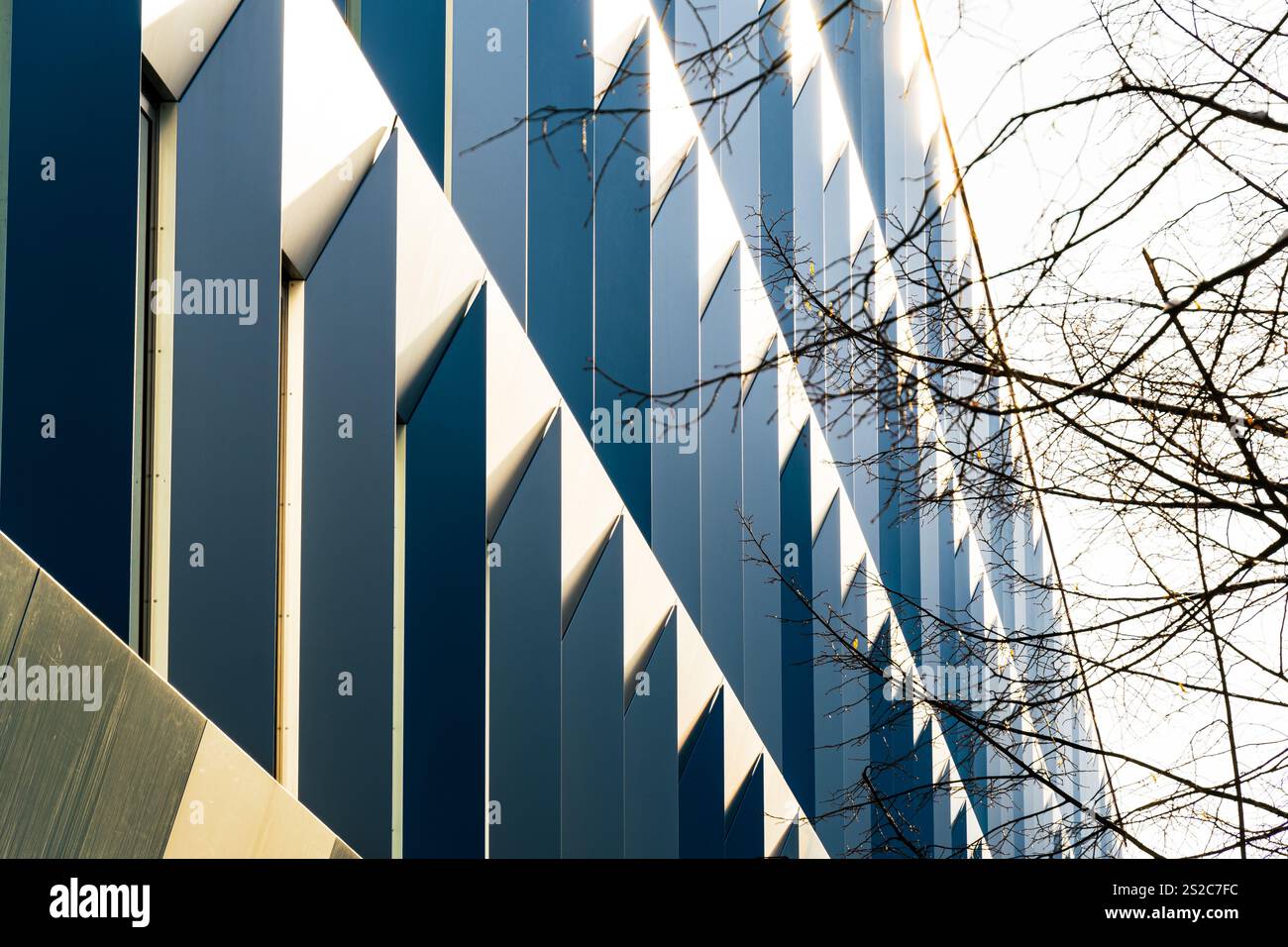 Abstract Modern Facade with Geometric Patterns, Blue and Yellow Panels, and Sunlight Reflections ...