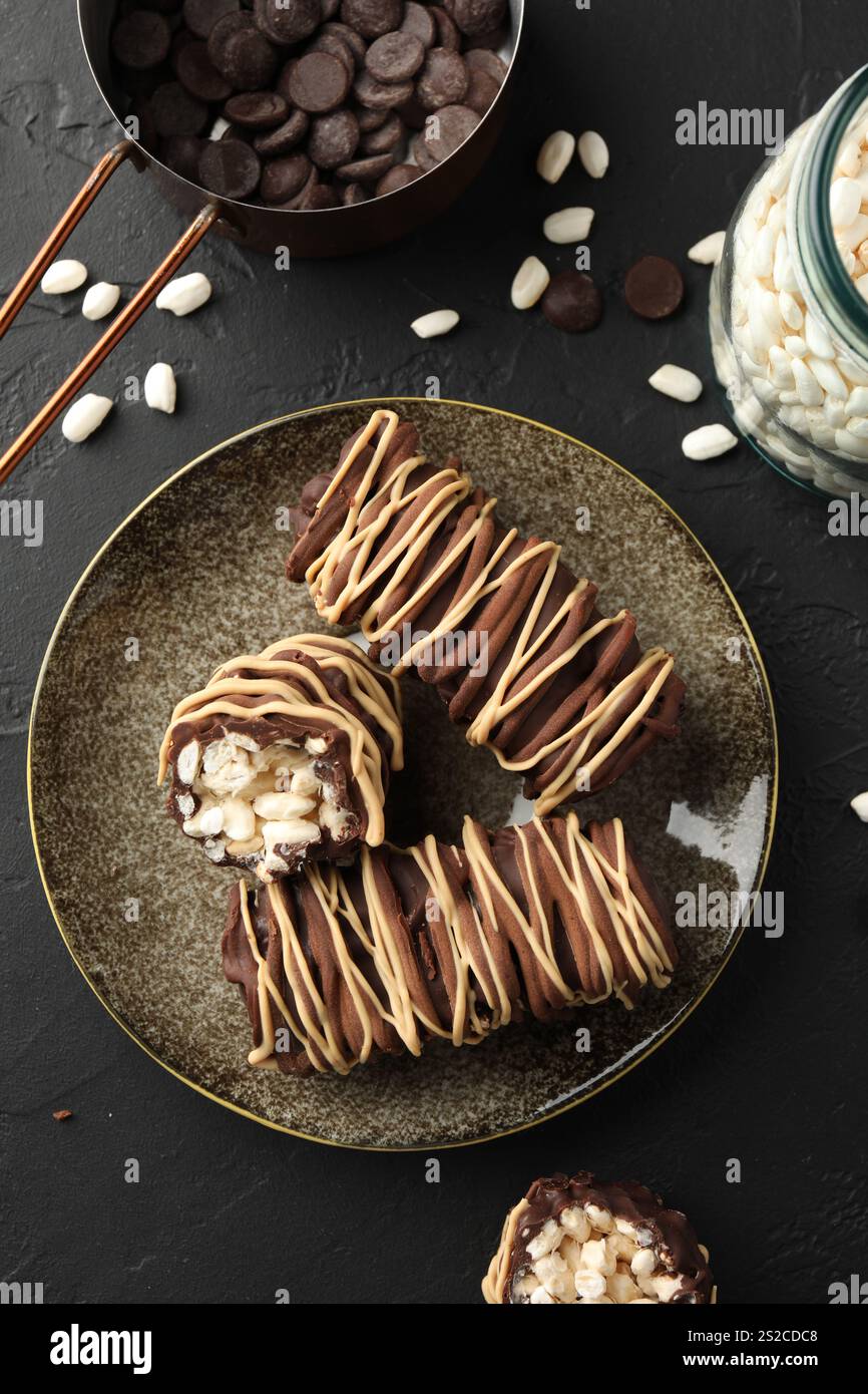 Delicious chocolate puffed rice bars and ingredients on dark gray ...