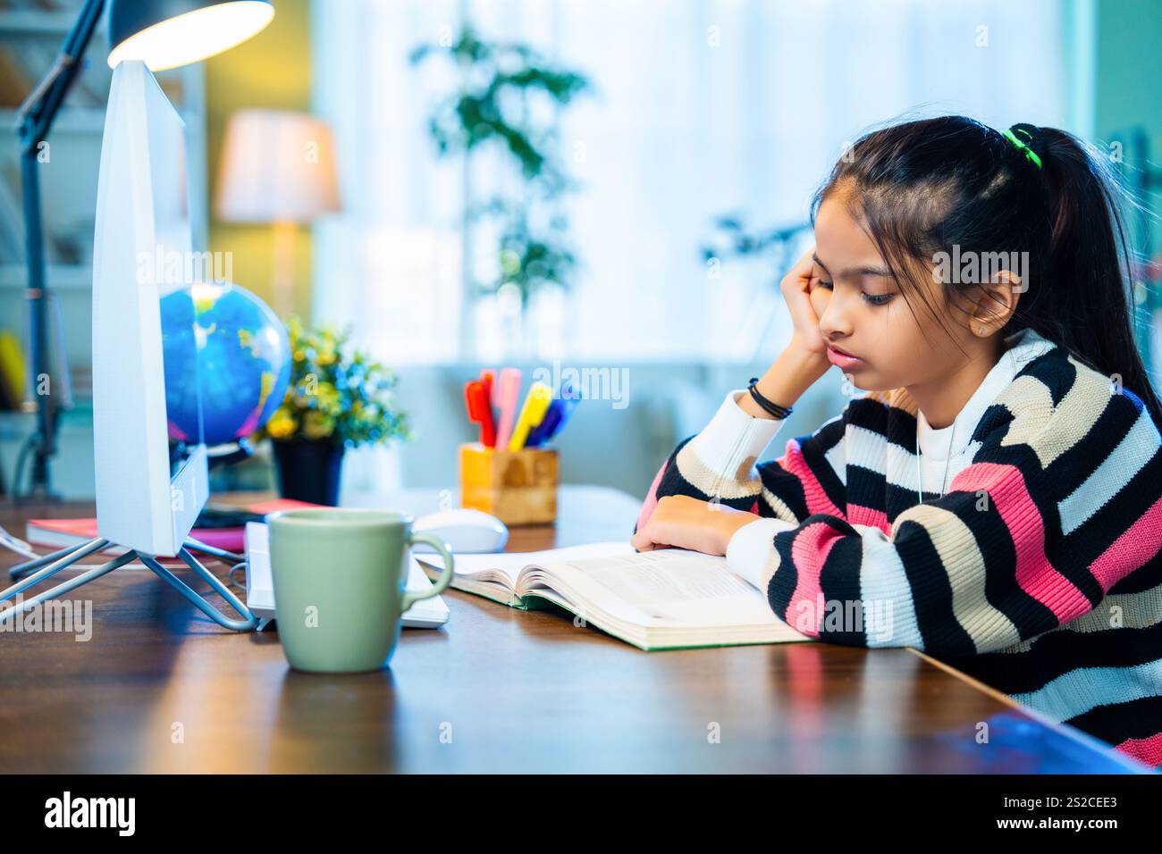 Studious Indian Asian Elementary Grade Girl Attending Virtual Online Class at Home Using ...