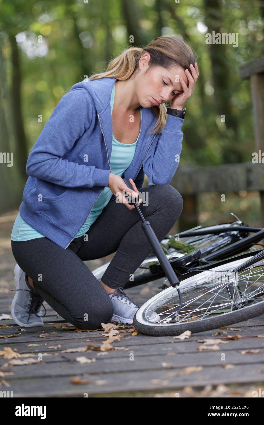 woman with puncture and bicycle pump looking fed up Stock Photo - Alamy