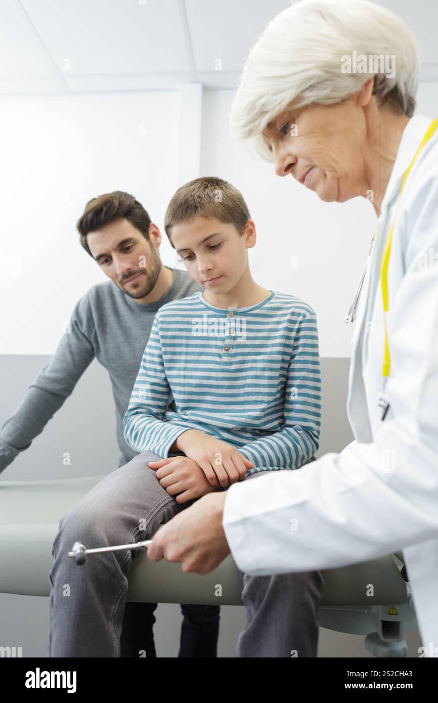 female doctor checking knee reflex on a child patient Stock Photo - Alamy