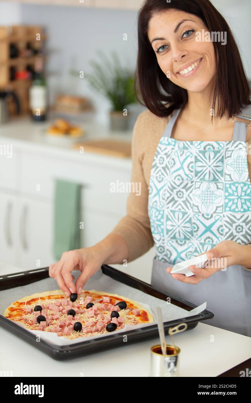 woman making a pizza adding olive toppings Stock Photo - Alamy