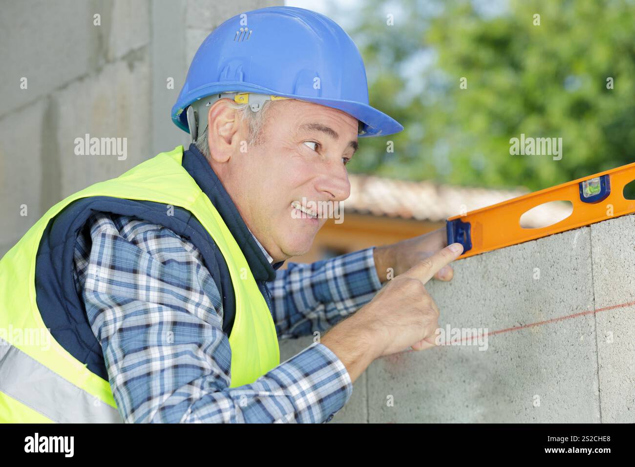 happy builder holding building level Stock Photo - Alamy