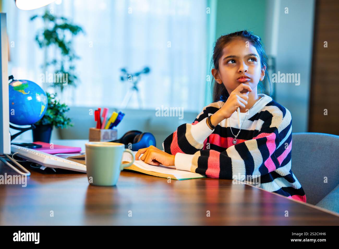 Studious Indian Asian Elementary Grade Girl Attending Virtual Online Class at Home Using ...