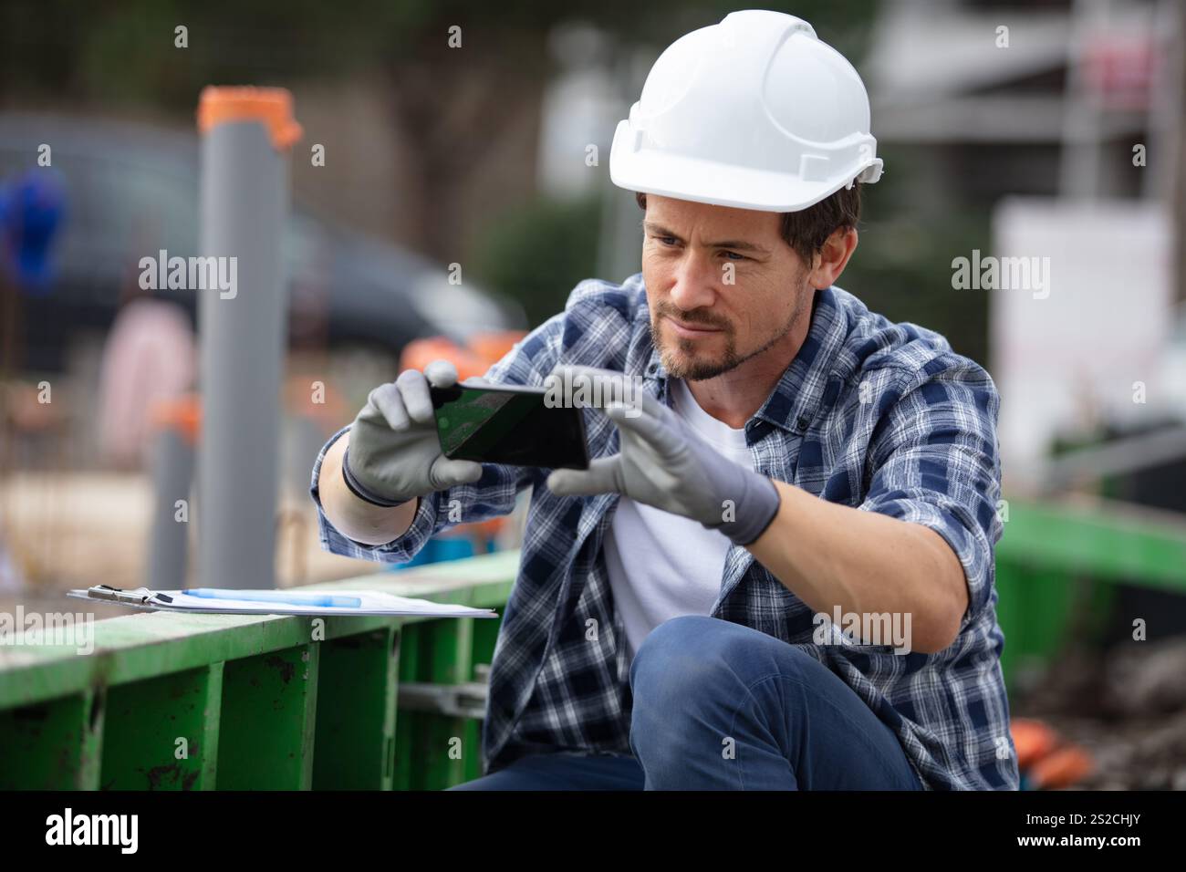 contractor taking photograph with smartphone on building site Stock ...