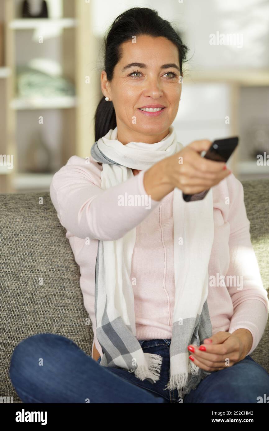 woman changing tv channels with remote control Stock Photo - Alamy
