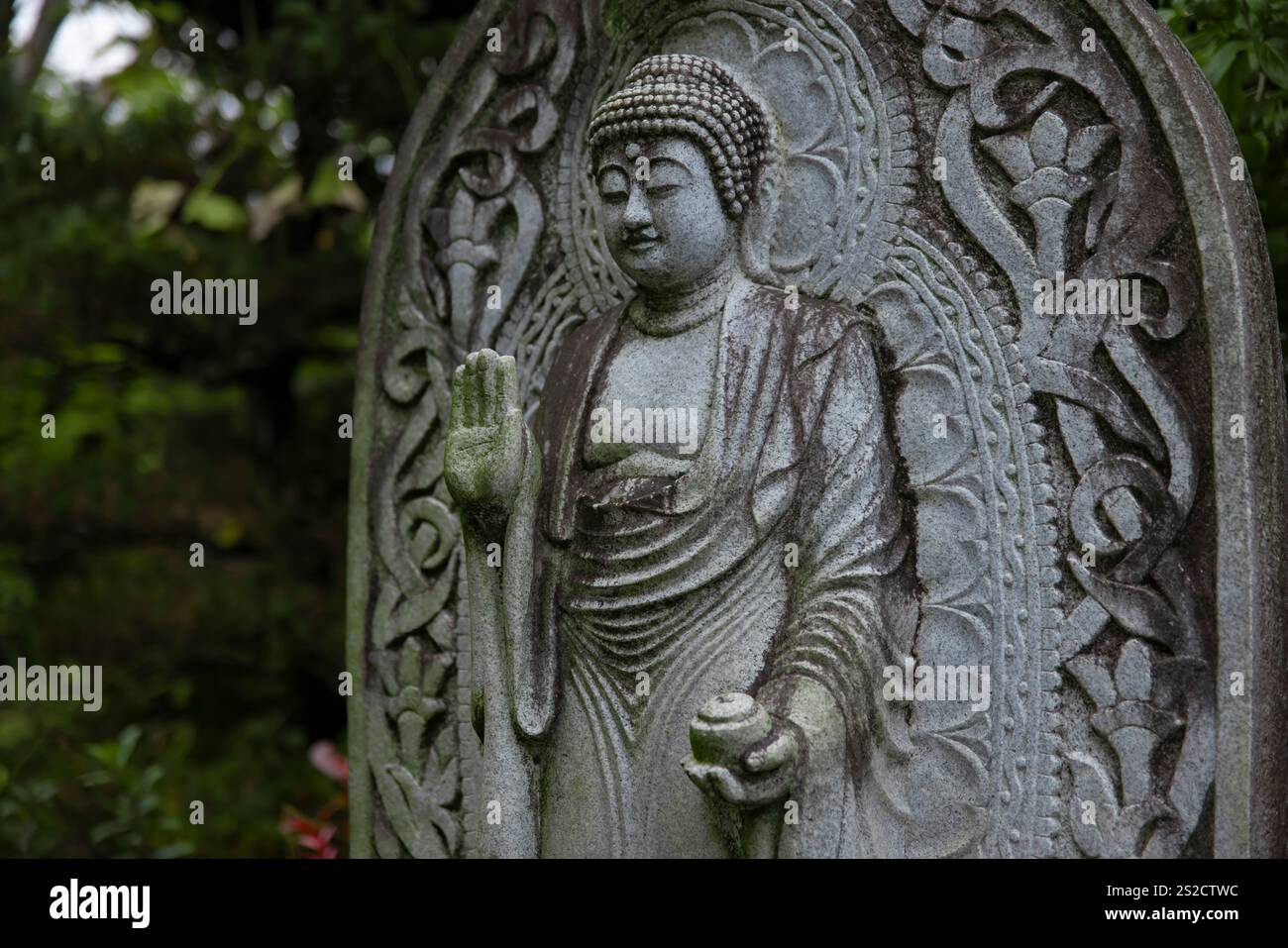 A religious stone statue of Medicine Buddha at Japanese buddhism temple ...