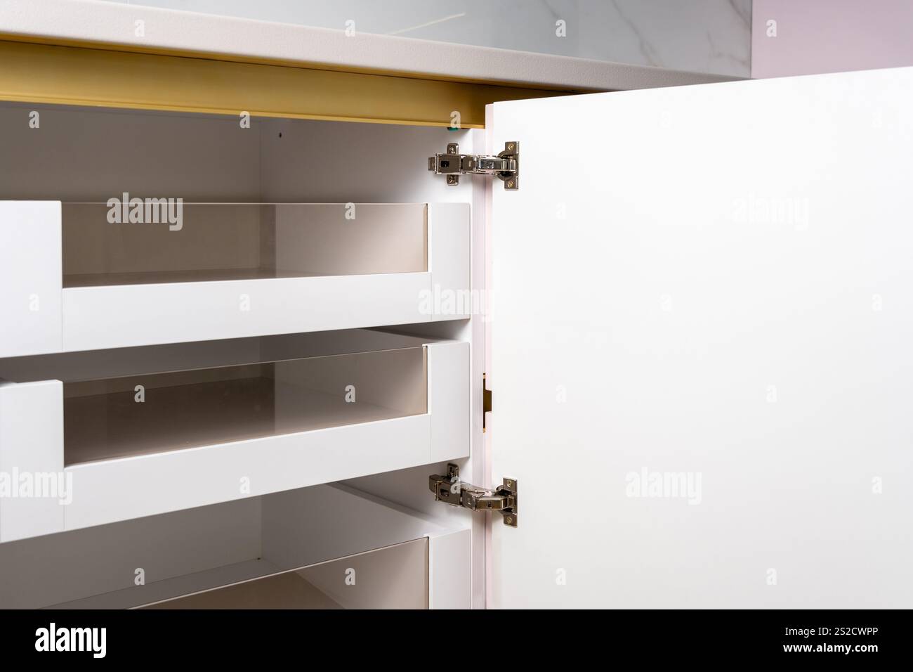 A modern, empty kitchen cabinet featuring sleek white design and ...