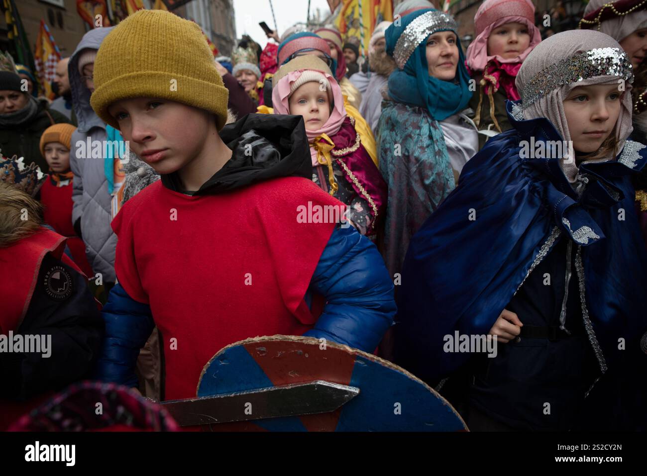 Children dressed as knights walk through city streets during the ...