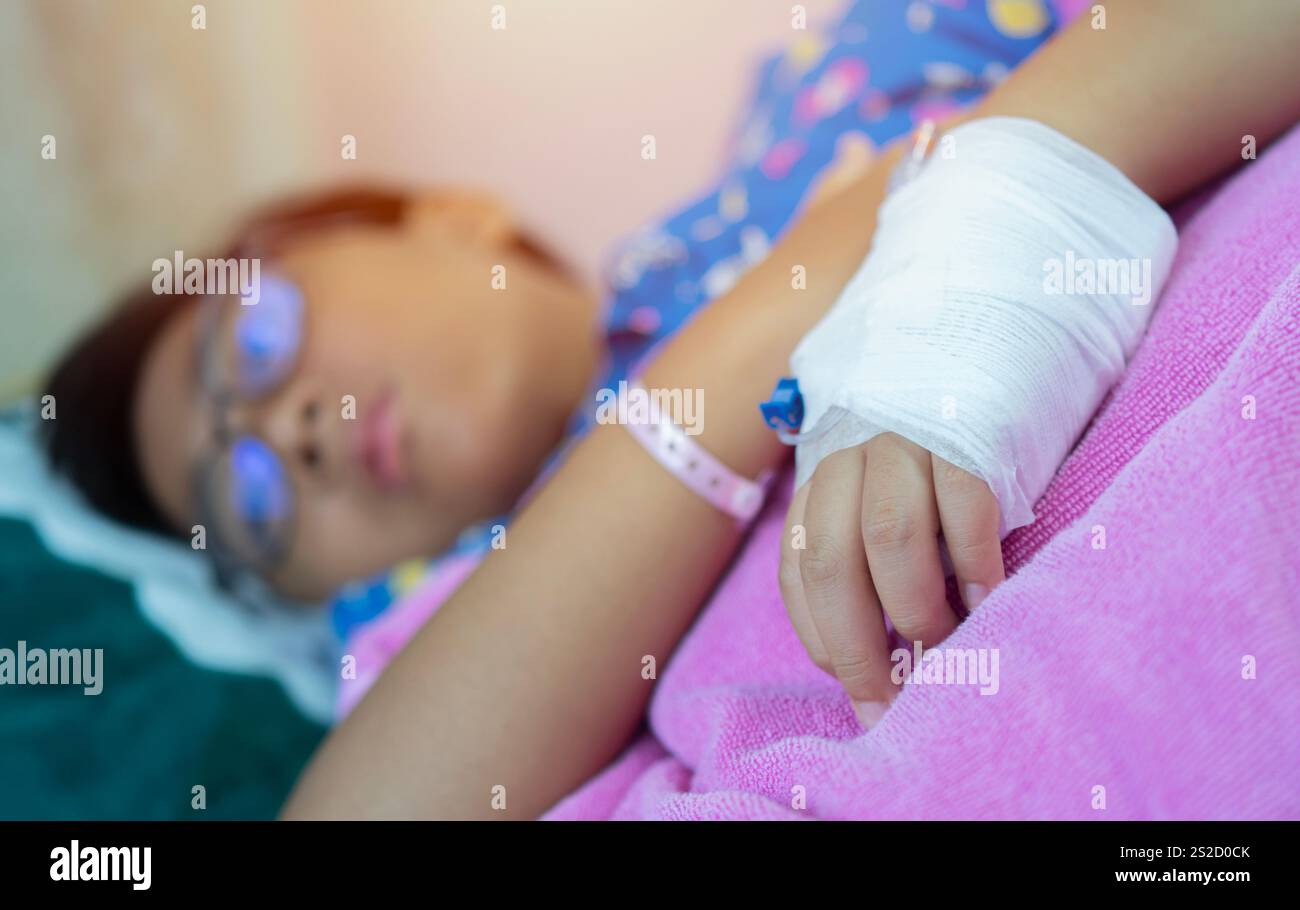 Selective focus of child's patient hand with saline intravenous (iv ... Selective focus of child's patient hand with saline intravenous (iv ...