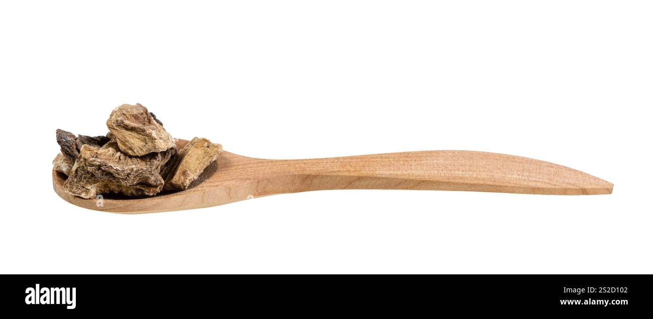 pieces of dried chicory roots in wooden spoon isolated on white ...