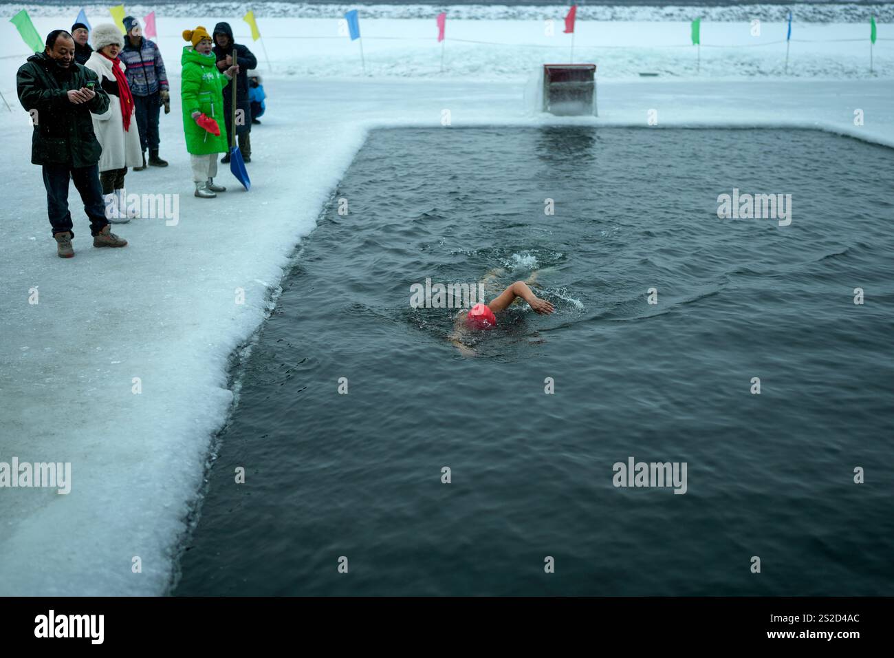 Residents watch a woman swim in a pool carved from ice on the frozen ...