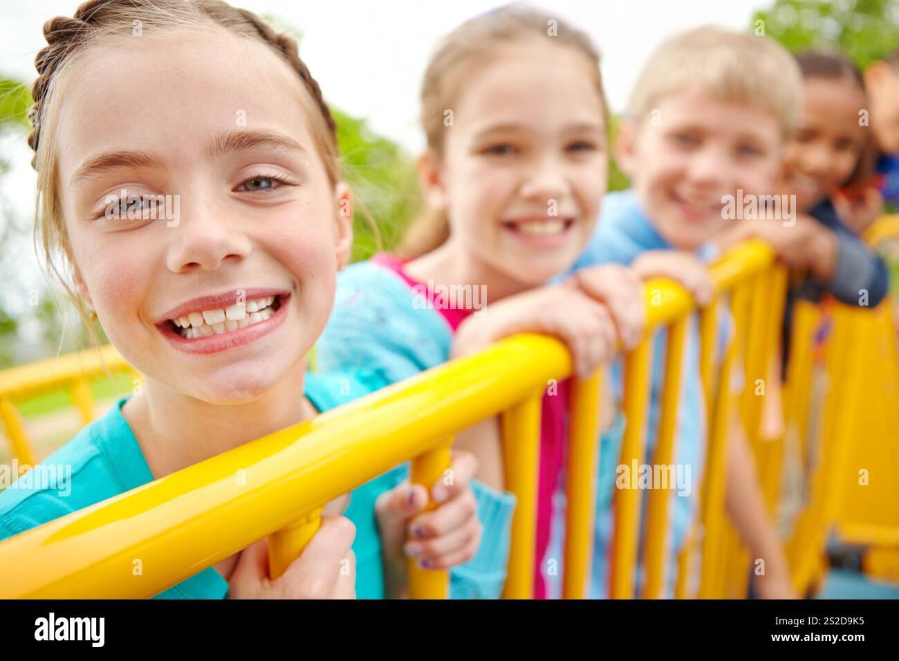 Girl, friends and smile on playground for vacation, childhood and having fun on jungle gym ...