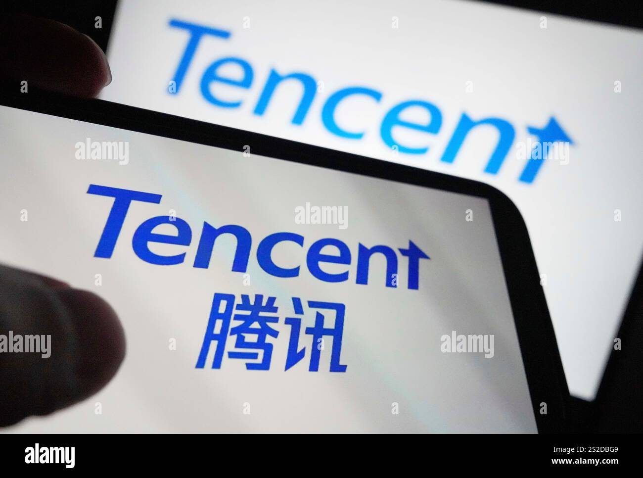 The logo of Chinese IT company "Tencent" are displayed on the screens of smartphone and PC in ...