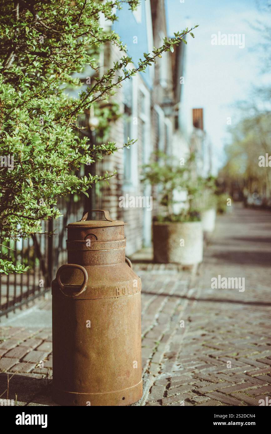 Traditional rusty metal milk churn in a cobbled street, Netherlands ...