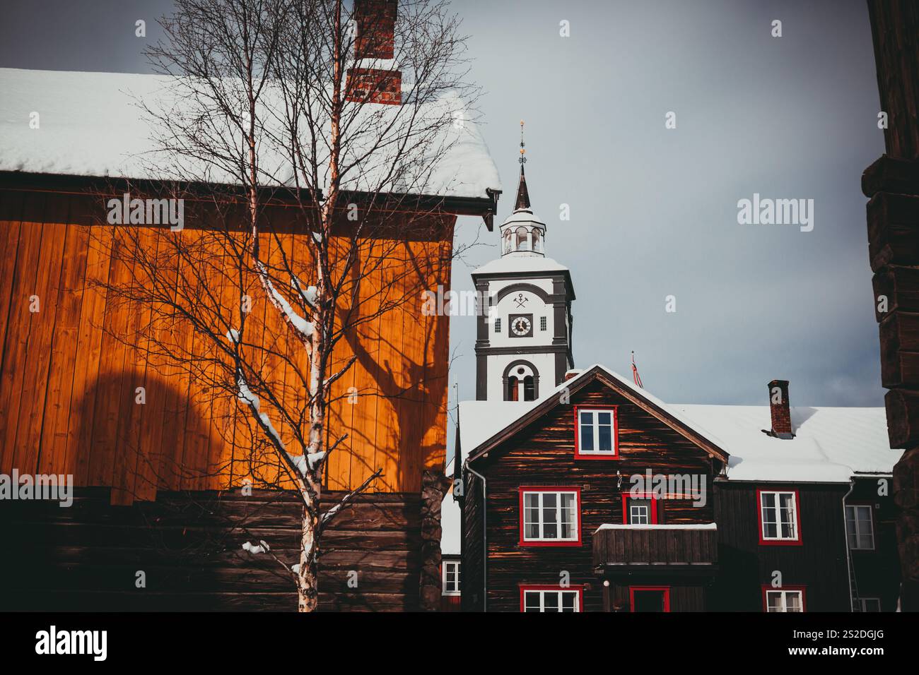 Wooden houses and iconic clock tower in Røros, Norway, covered in thick ...