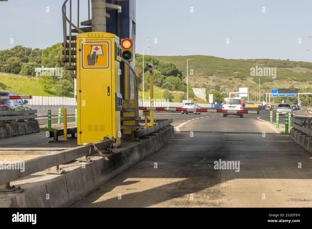 Cars approaching highway toll booth with red traffic light and lowered ...