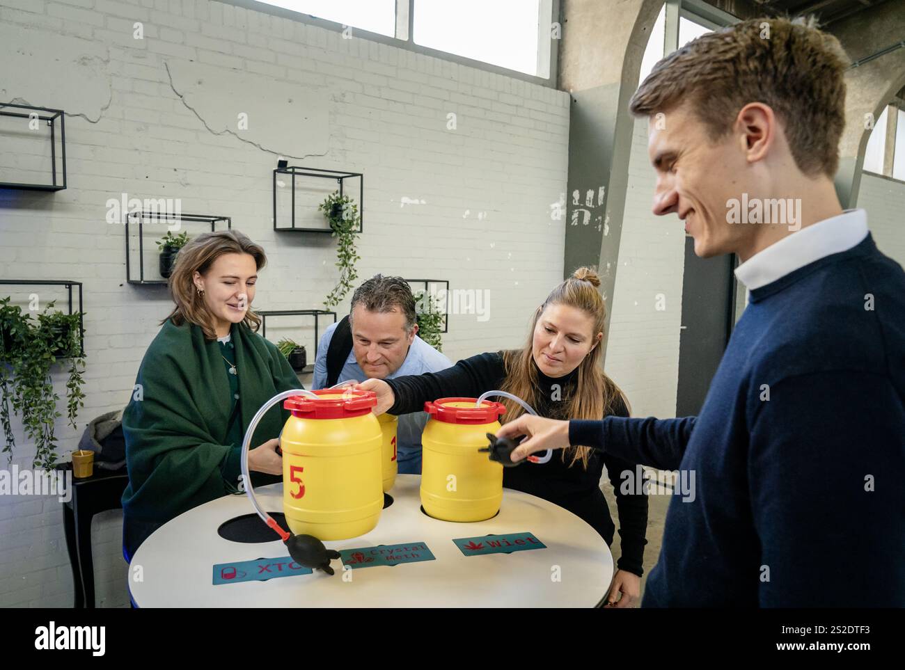 DEN HAAG - Attendees smell yellow barrels to identify drugs, during the ...