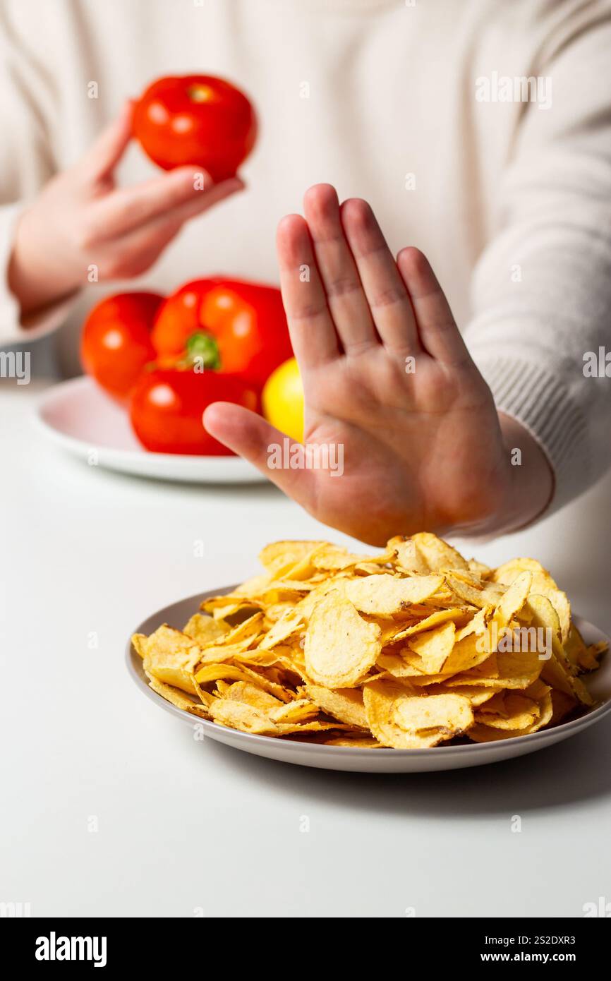 Vertical shot of Woman saying "NO" to chips. Hand sign to refuse junk ...