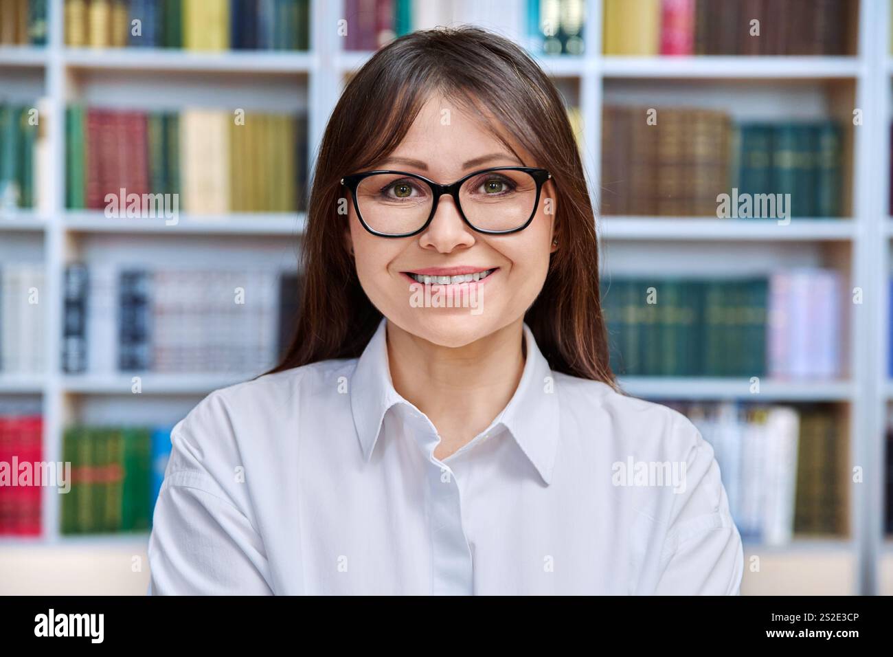 Headshot portrait of confident elegant mature business woman in library ...