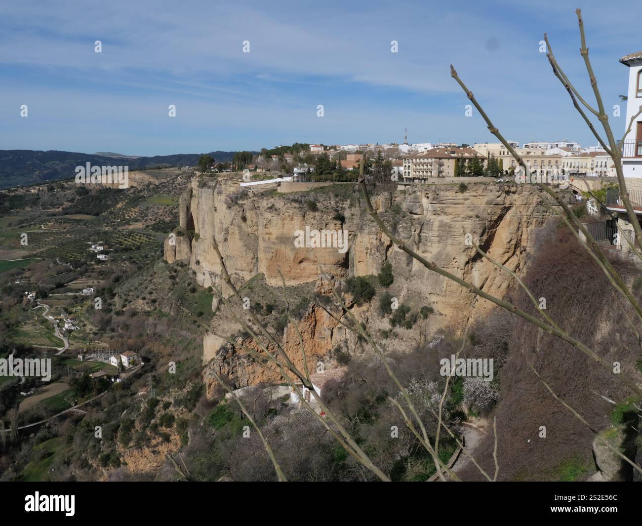Houses stand spectacularly on the edge above a steep rock face next to ...