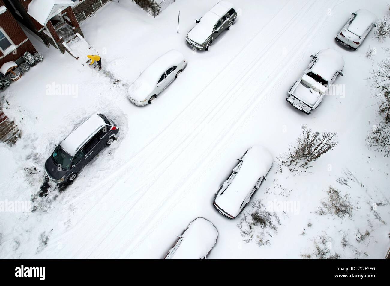 FILE - A person clears snow from front stairs of a home following a ...
