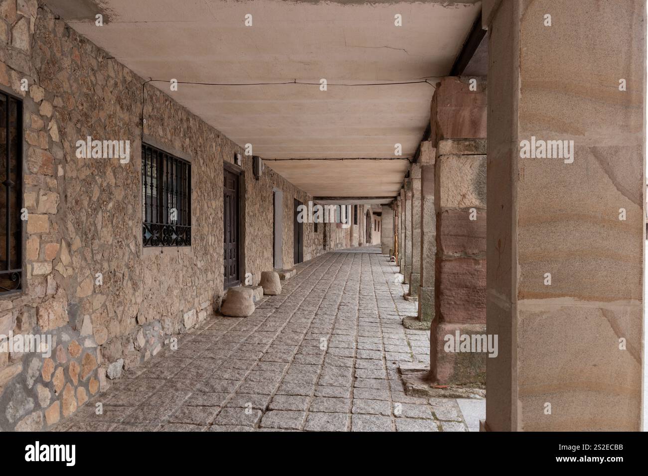 Historic stone colonnade with arched walkway and rustic architecture in ...