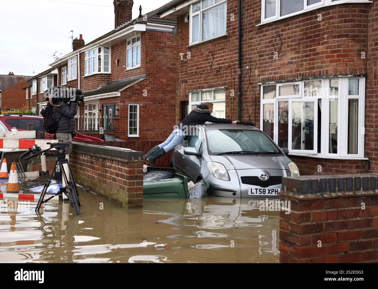 Qasim Abdullah talks to a journalist through the window of his flooded home in Loughborough ...