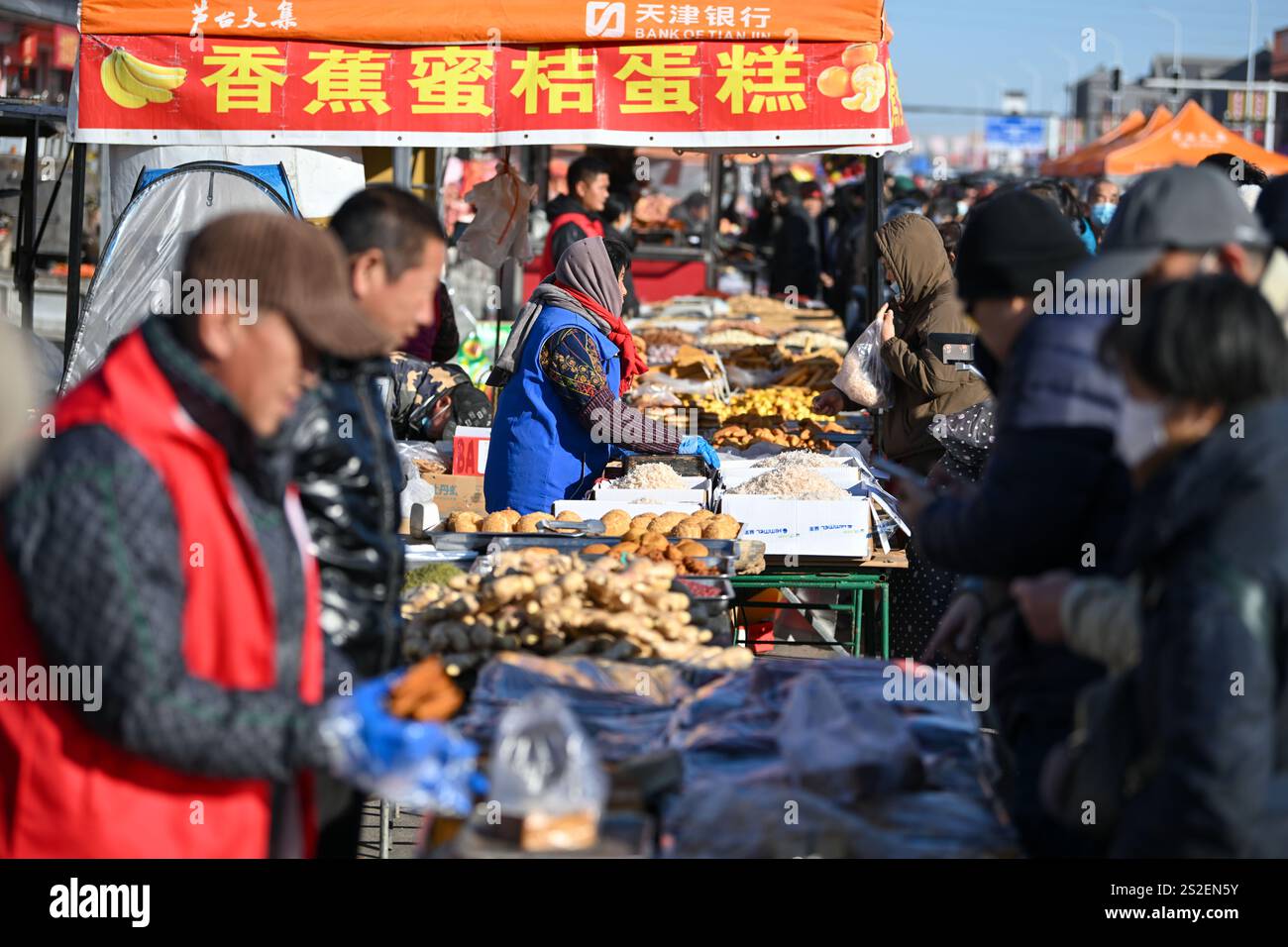 Tianjin. 7th Jan, 2025. People visit an open-air market in Ninghe ...
