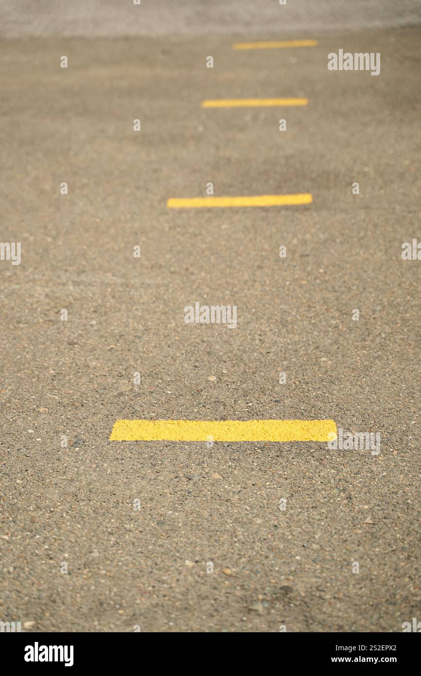 Close up view of yellow road lines on asphalt pavement for traffic ...