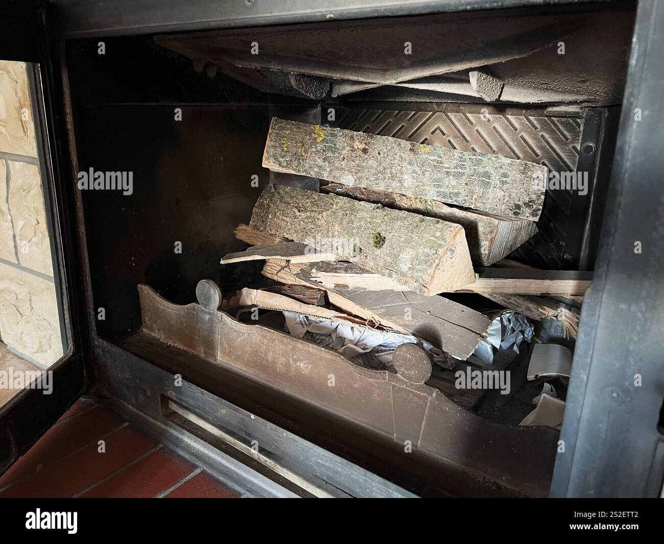 A photograph of logs and kindling carefully stacked in a fireplace ...