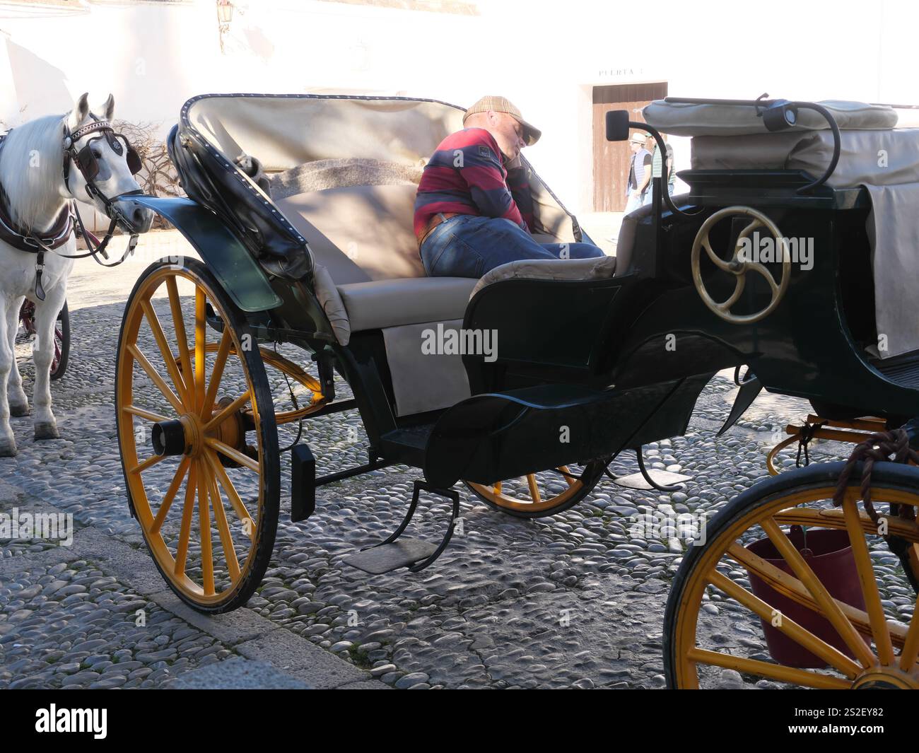 A coachman sleeps in his open carriage waiting for tourists in Ronda ...