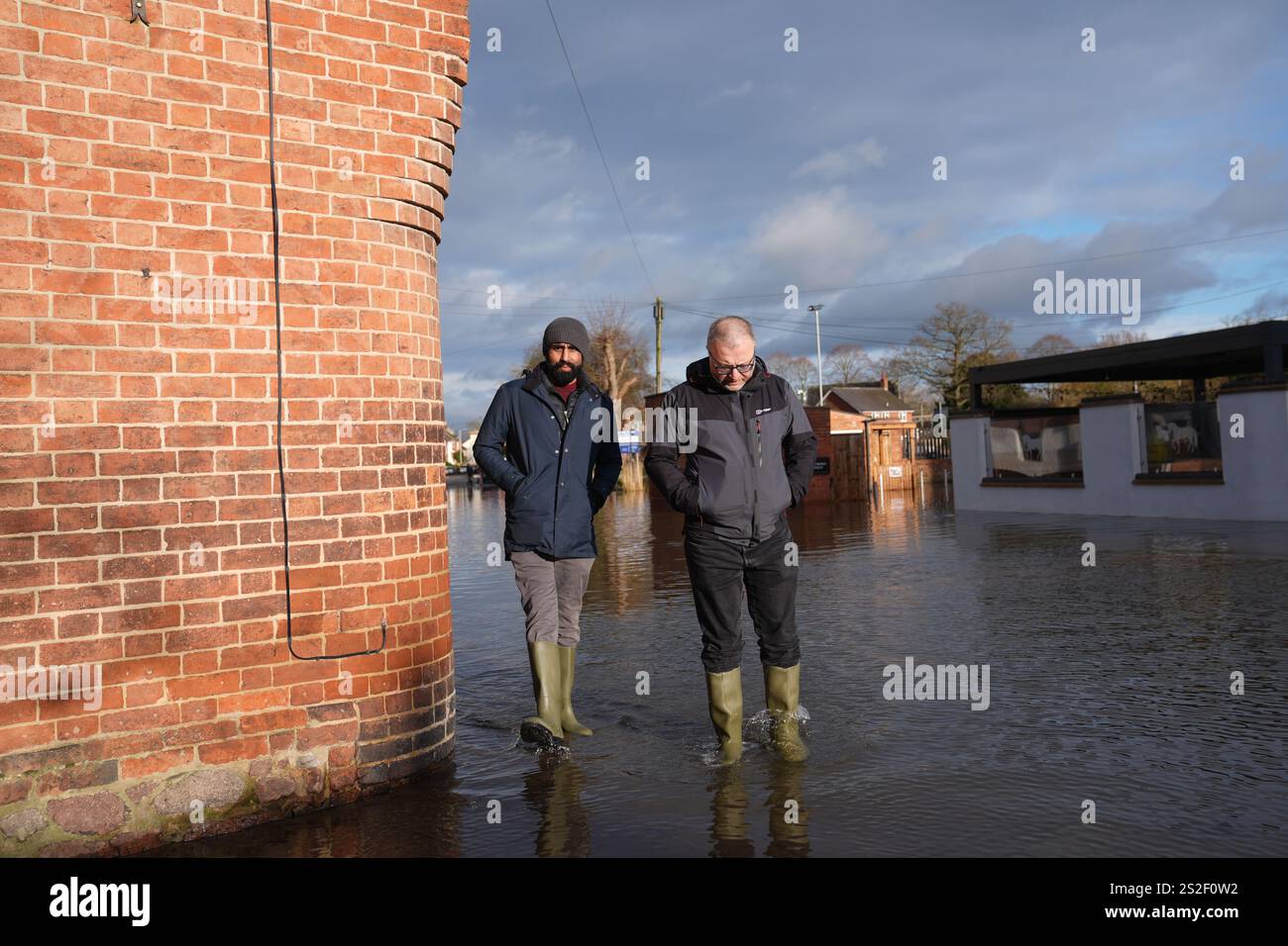 Jeevun Sandher, MP for Loughborough (left) walking through floodwater ...