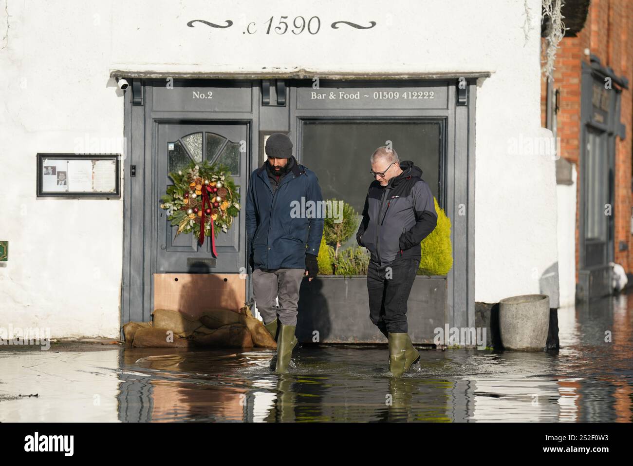 Jeevun Sandher, MP for Loughborough (left) walking through floodwater ...