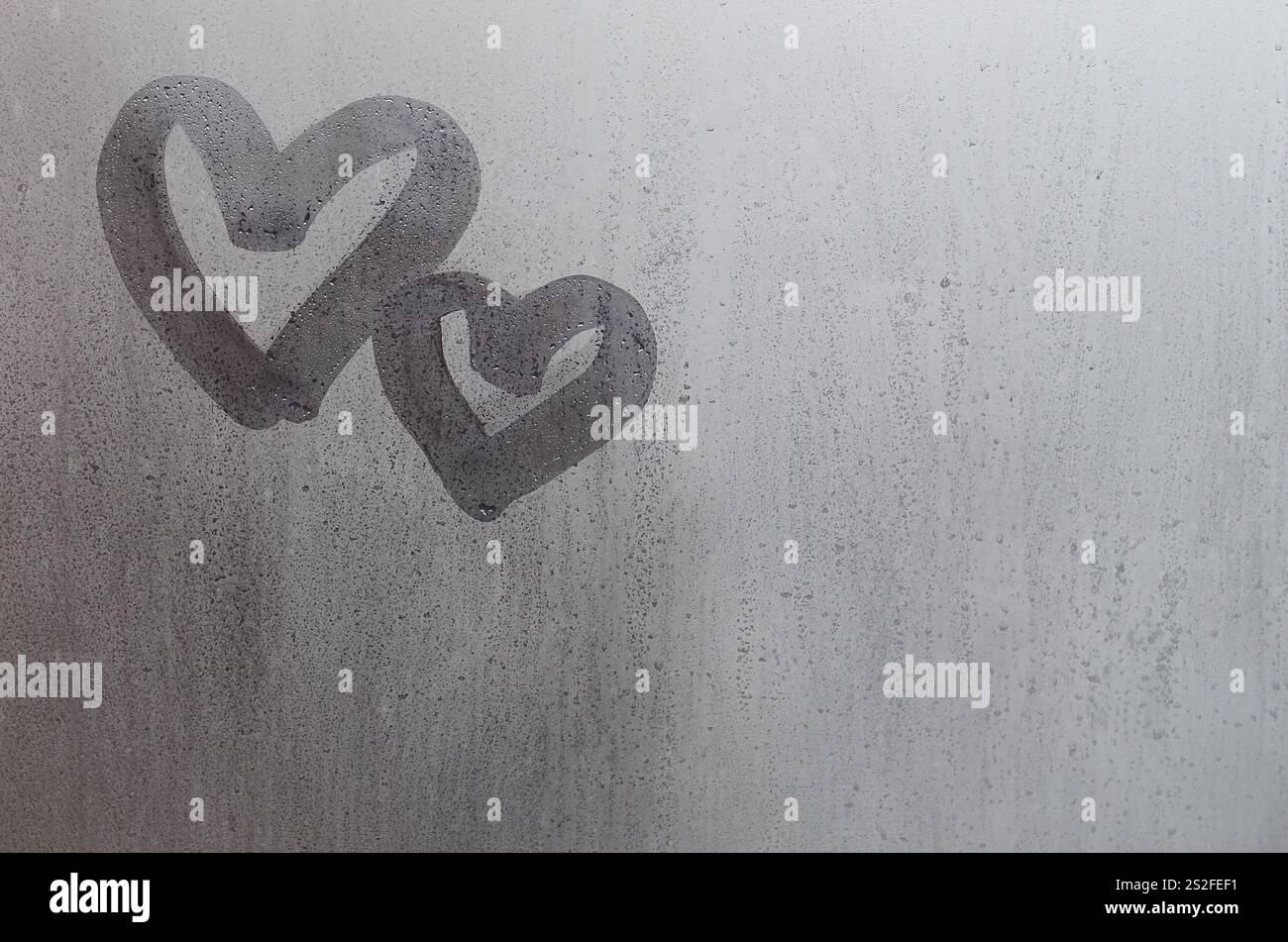 Couple of abstract blurred love heart symbol drawn by hand on the wet ...