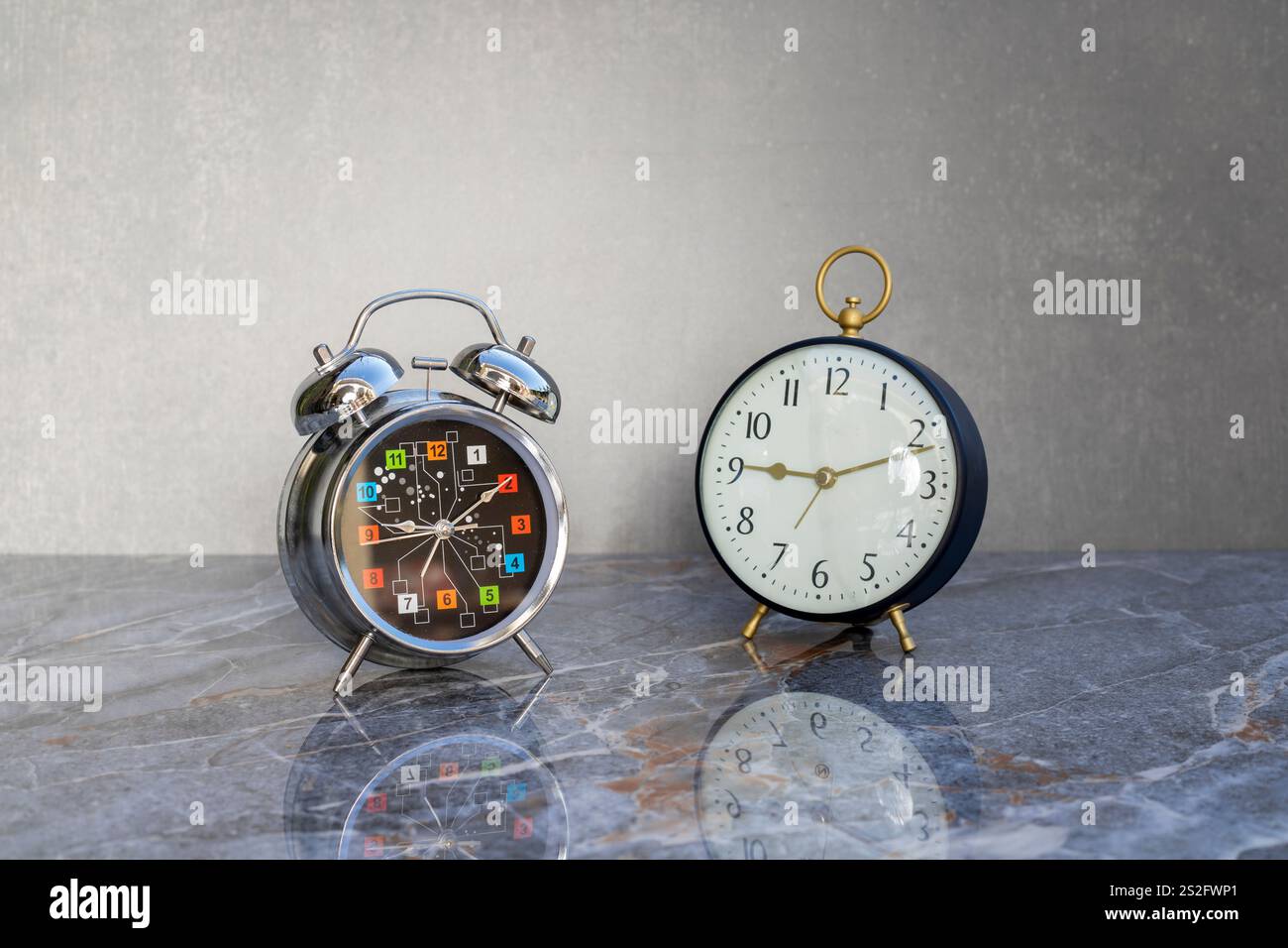 Two retro table clocks with reflection on polished marble surface Stock ...