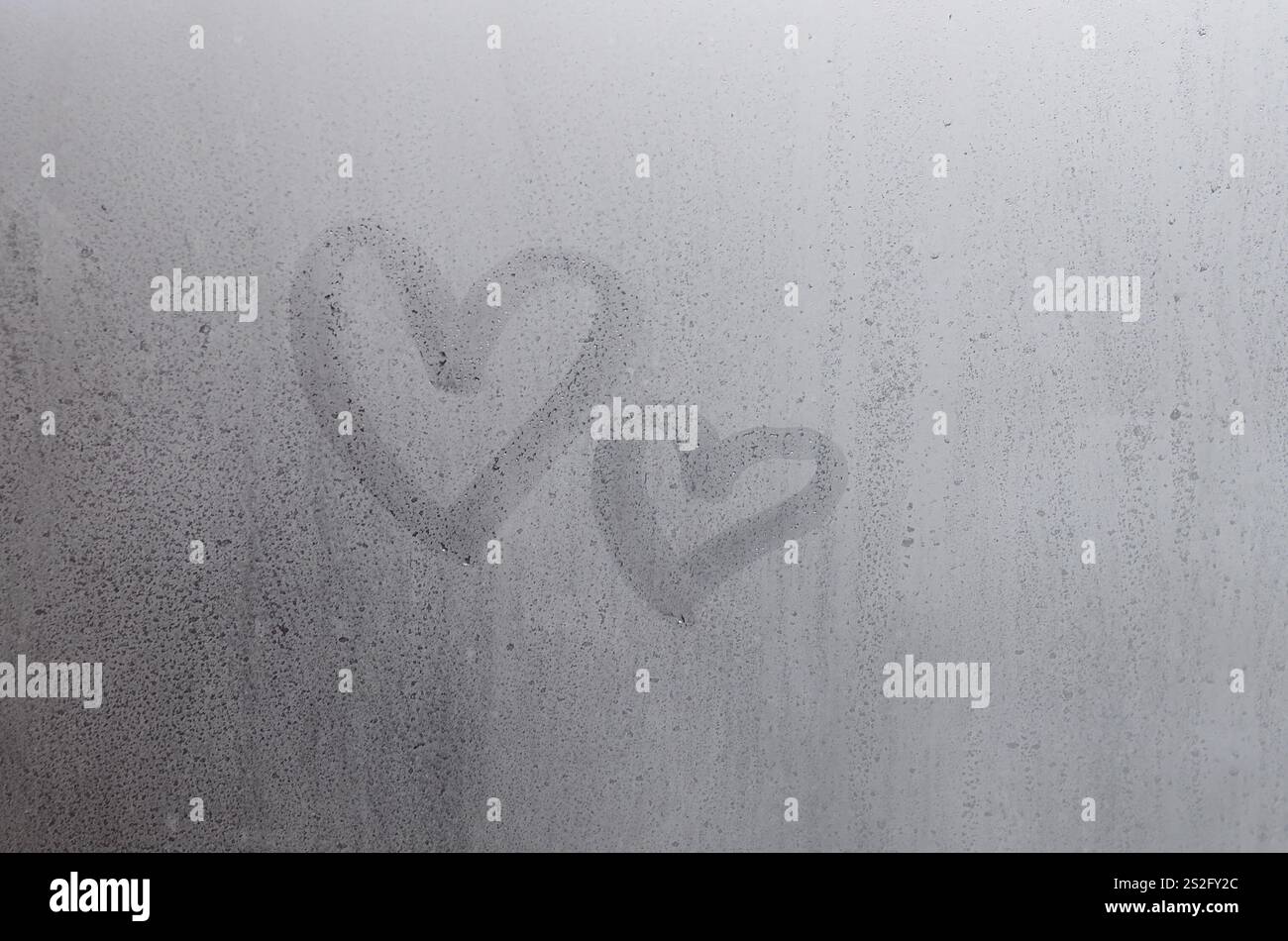 Couple of abstract blurred love heart symbol drawn by hand on the wet ...
