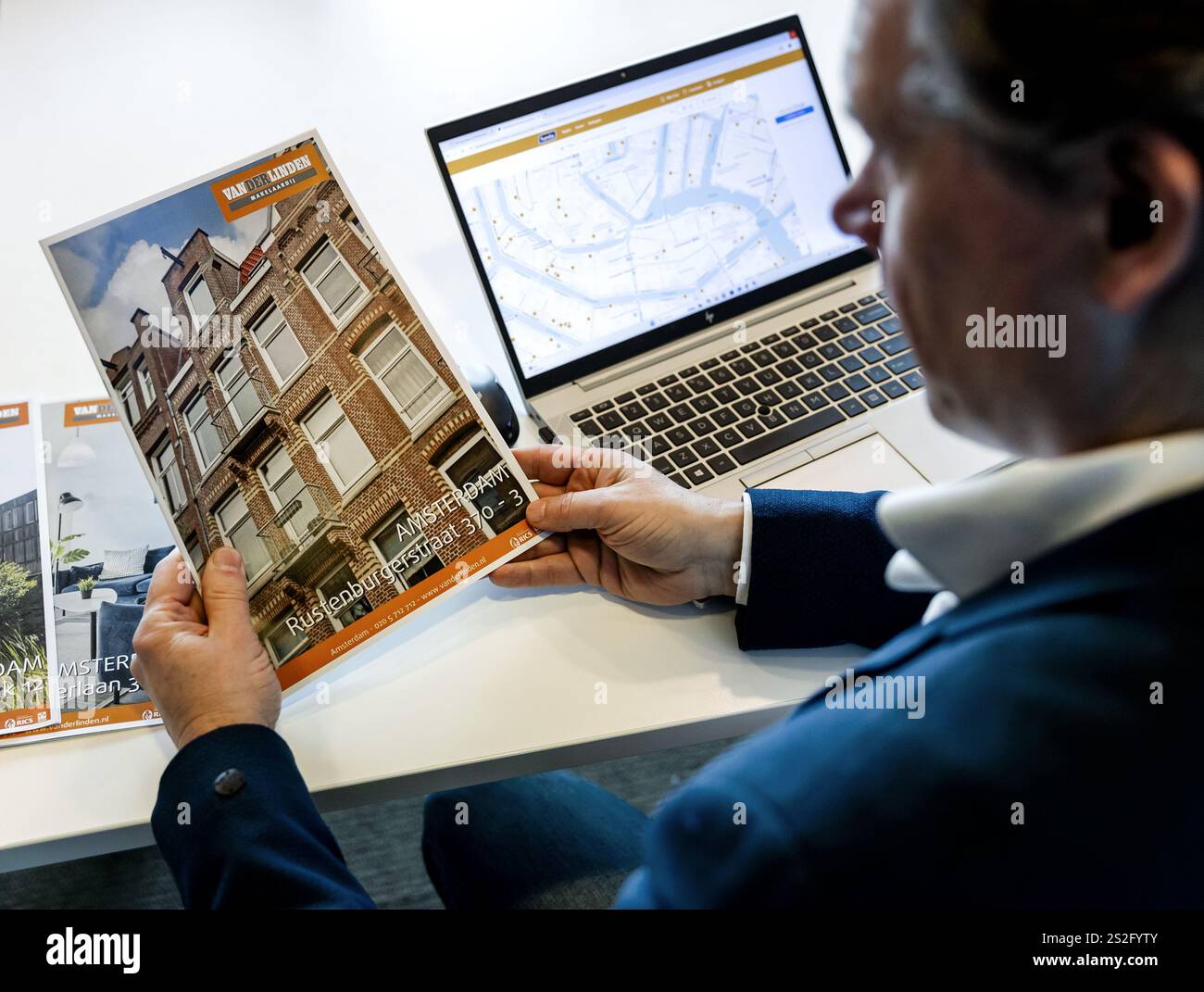 AMSTERDAM - A real estate agent at work in a real estate office. ANP ...