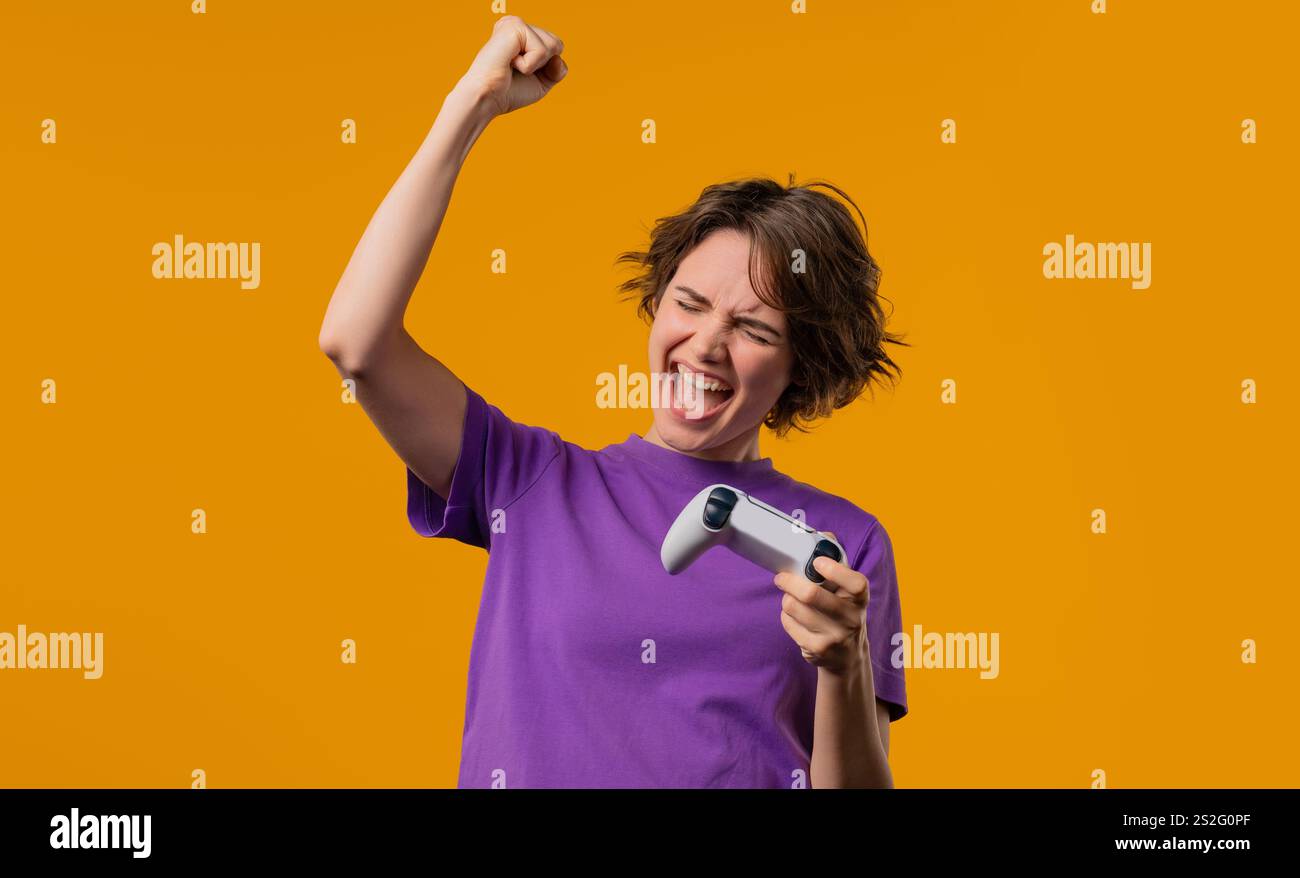 Young pretty gamer woman playing, winning online video game on console ...