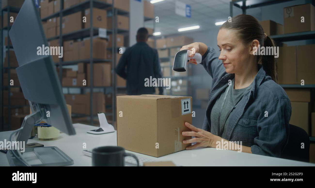 Logistics distribution center: Female post office employee scans cardboard parcel using barcode ...