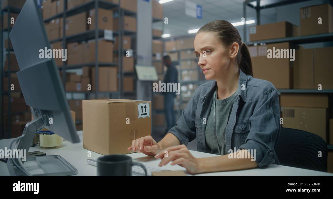 Logistics distribution center: Female post office employee scans cardboard parcel using barcode ...