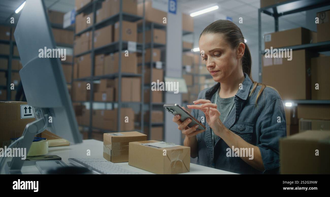Female logistics specialist scans parcels using smartphone, prepares packages for shipping ...