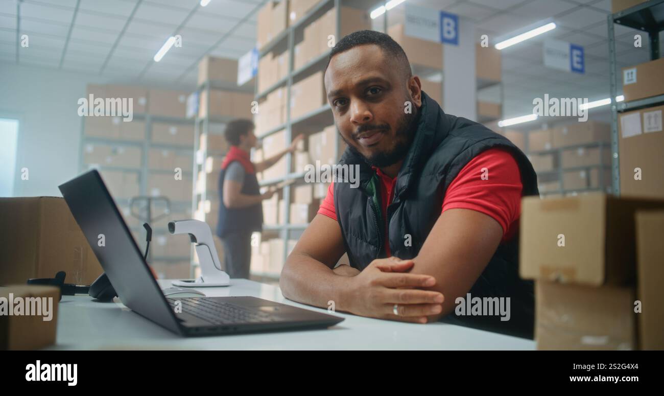 Portrait of African American post office employee scanning parcel with barcode scanner, using ...