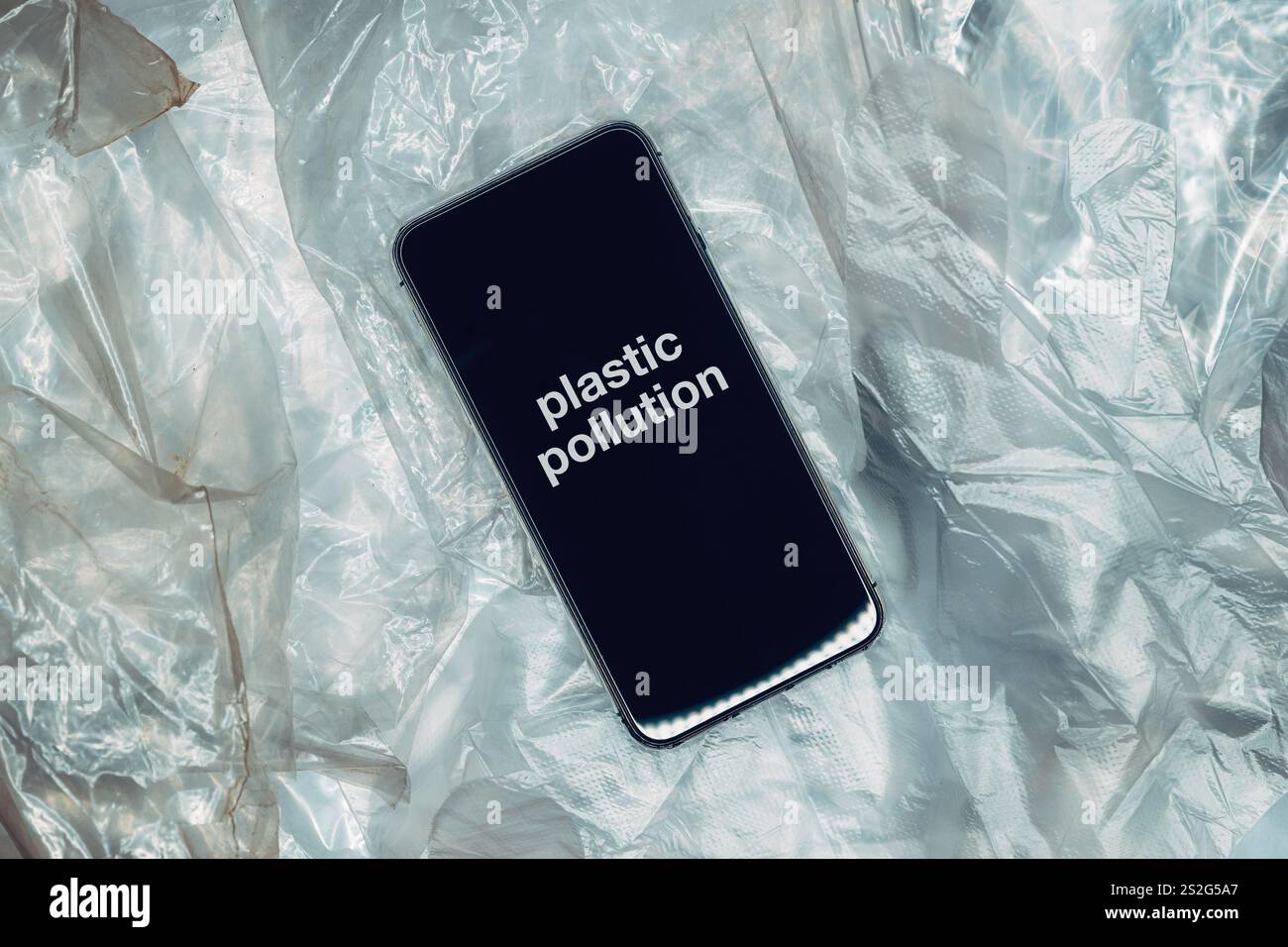Smartphone device with Plastic pollution text on screen over ...