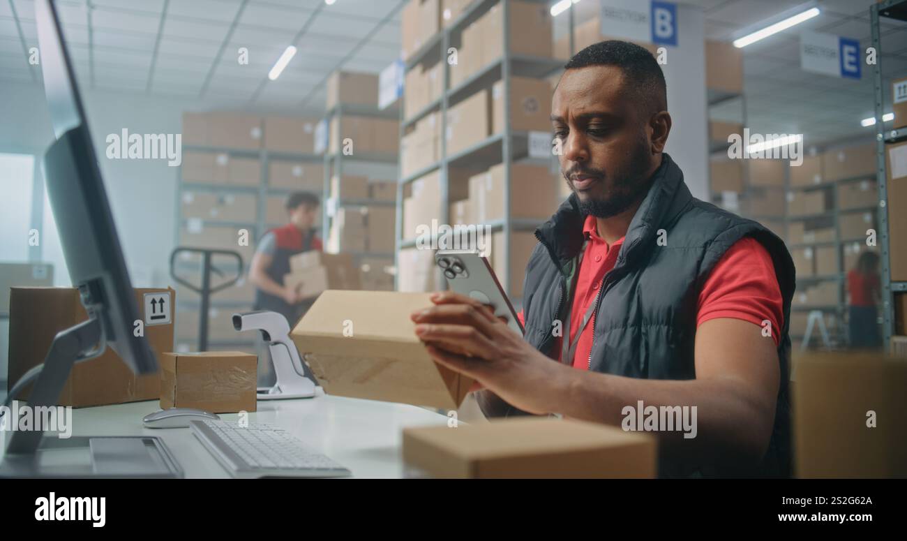 African American logistics manager scans parcels using smartphone ...